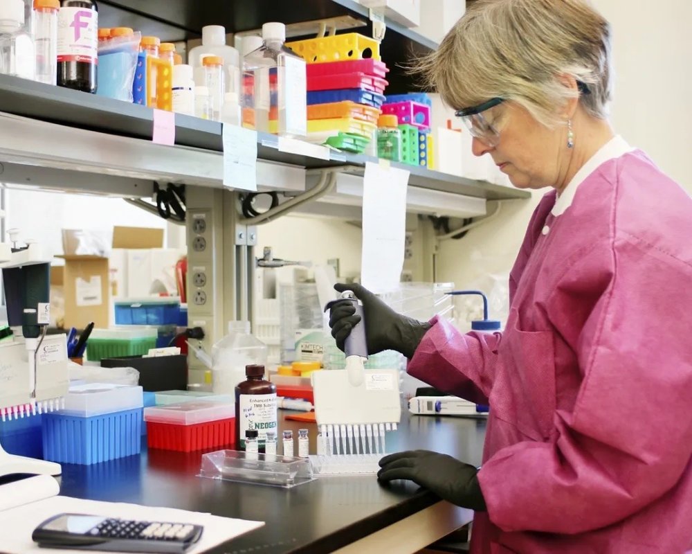 Futuristic female scientist in high-tech lab with glowing substance ...